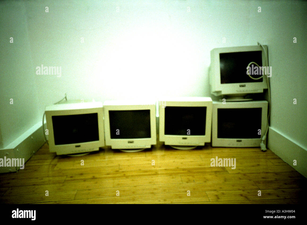 Computer monitors stacked against a wall Stock Photo - Alamy