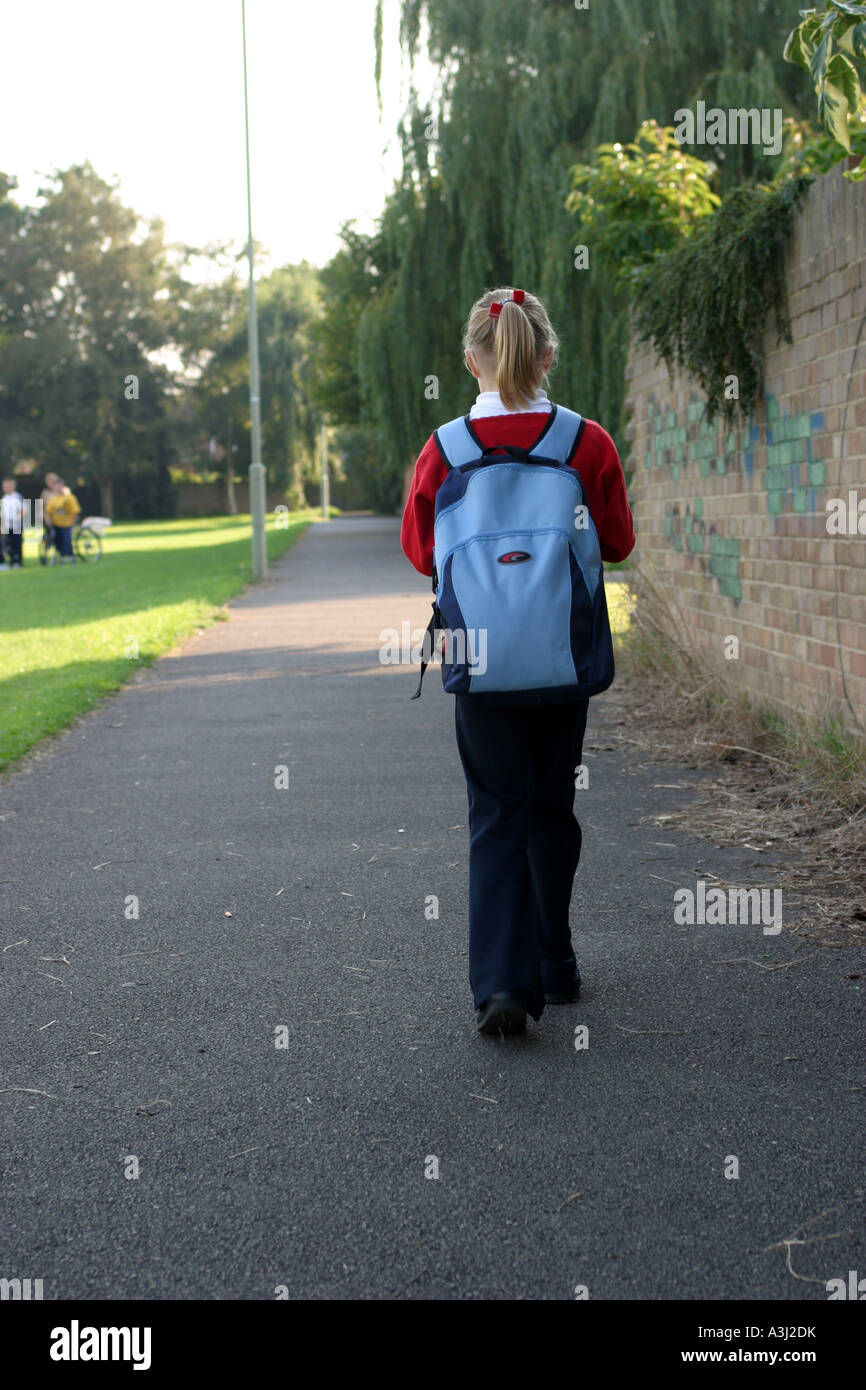 Girl on her way home from school walking past some graffiti Stock Photo ...