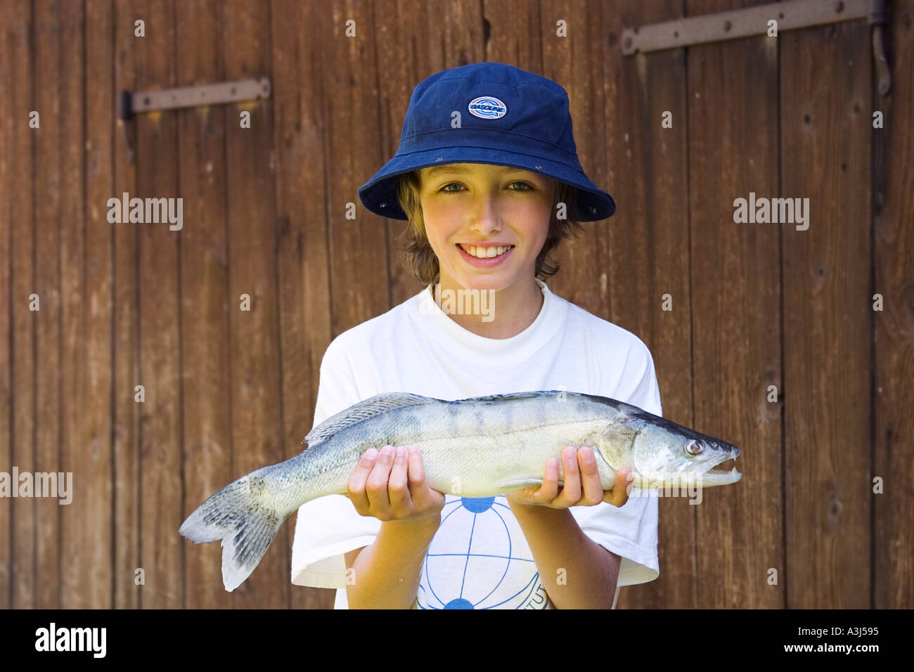 MR 10 years old boy shows proudly a zander Stock Photo - Alamy