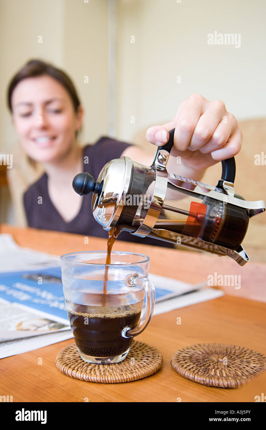 Woman pouring coffee Stock Photo - Alamy
