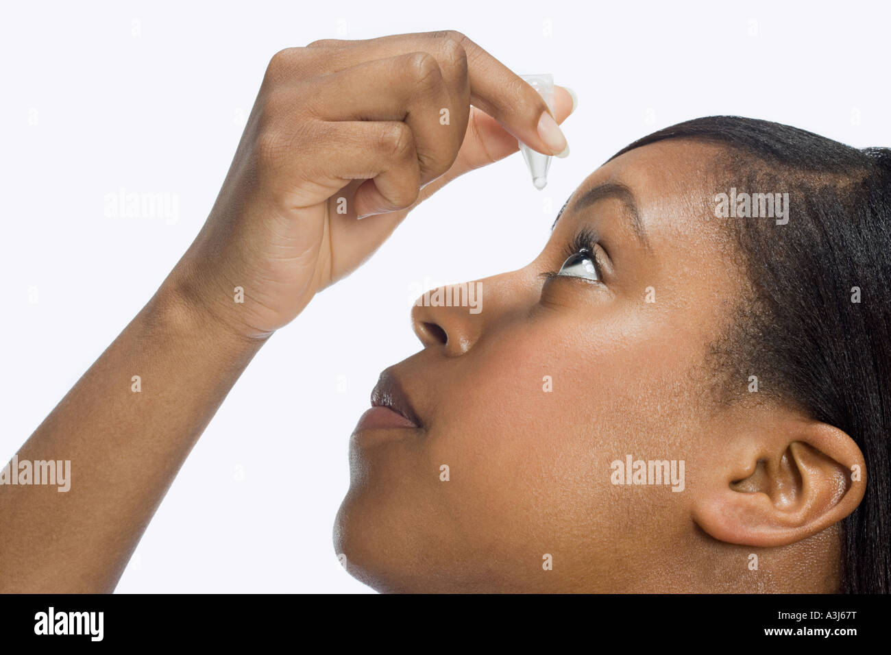 Woman using eye drops Stock Photo - Alamy