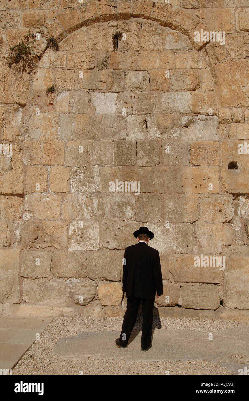 An orthodox Jew standing in front of the now-blocked triple arched ...
