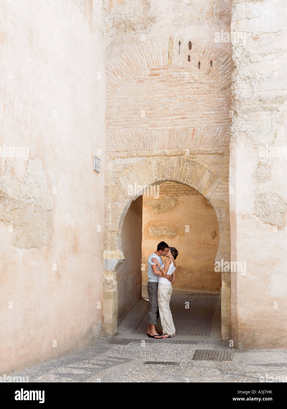 Couple kissing under arch Stock Photo - Alamy