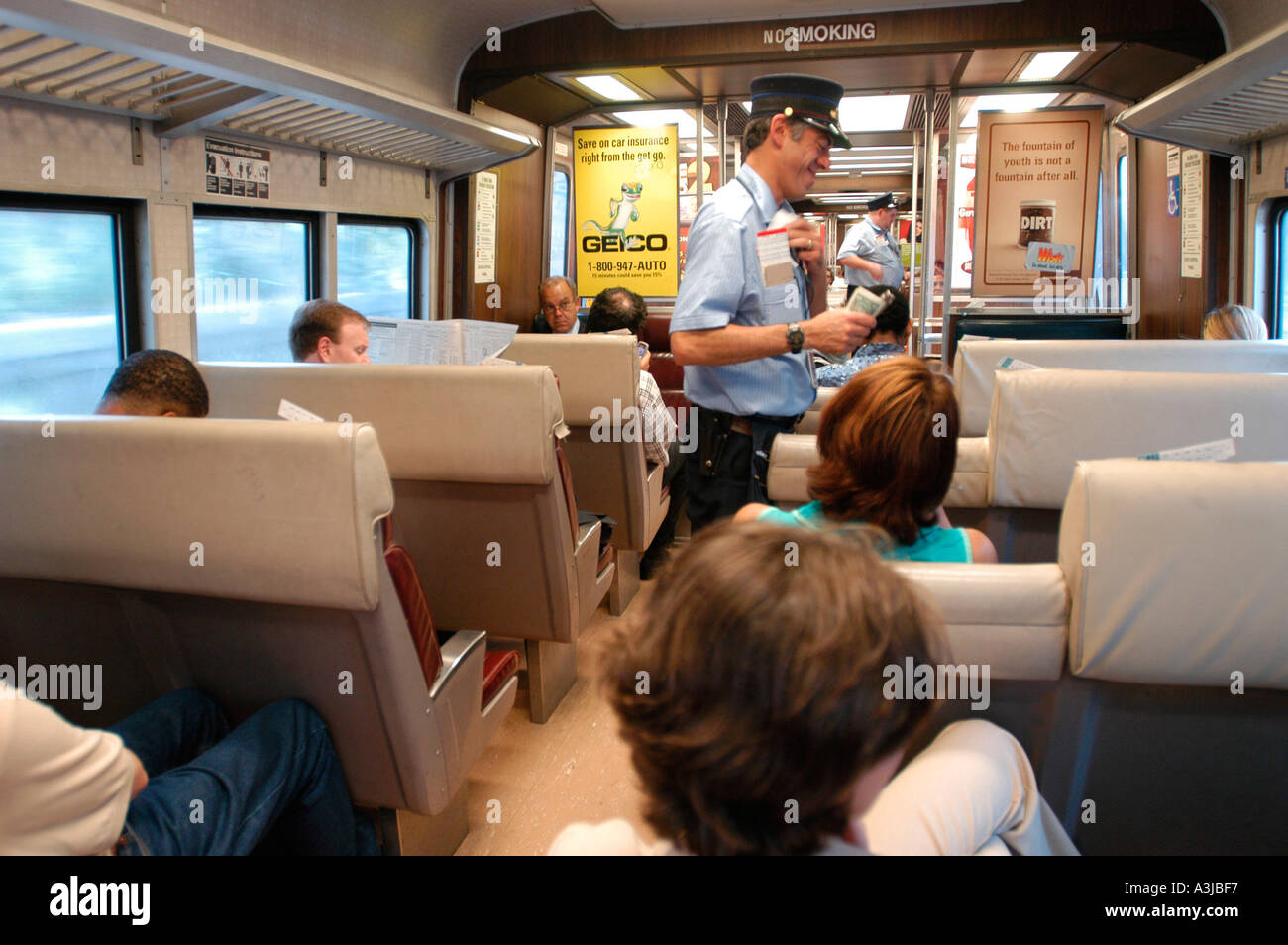 Conductor takes tickets on the 6 18 pm train Stock Photo - Alamy