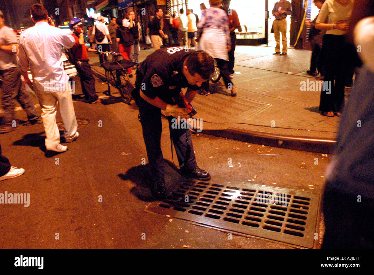 NYPD police officer searches for evidence Stock Photo - Alamy