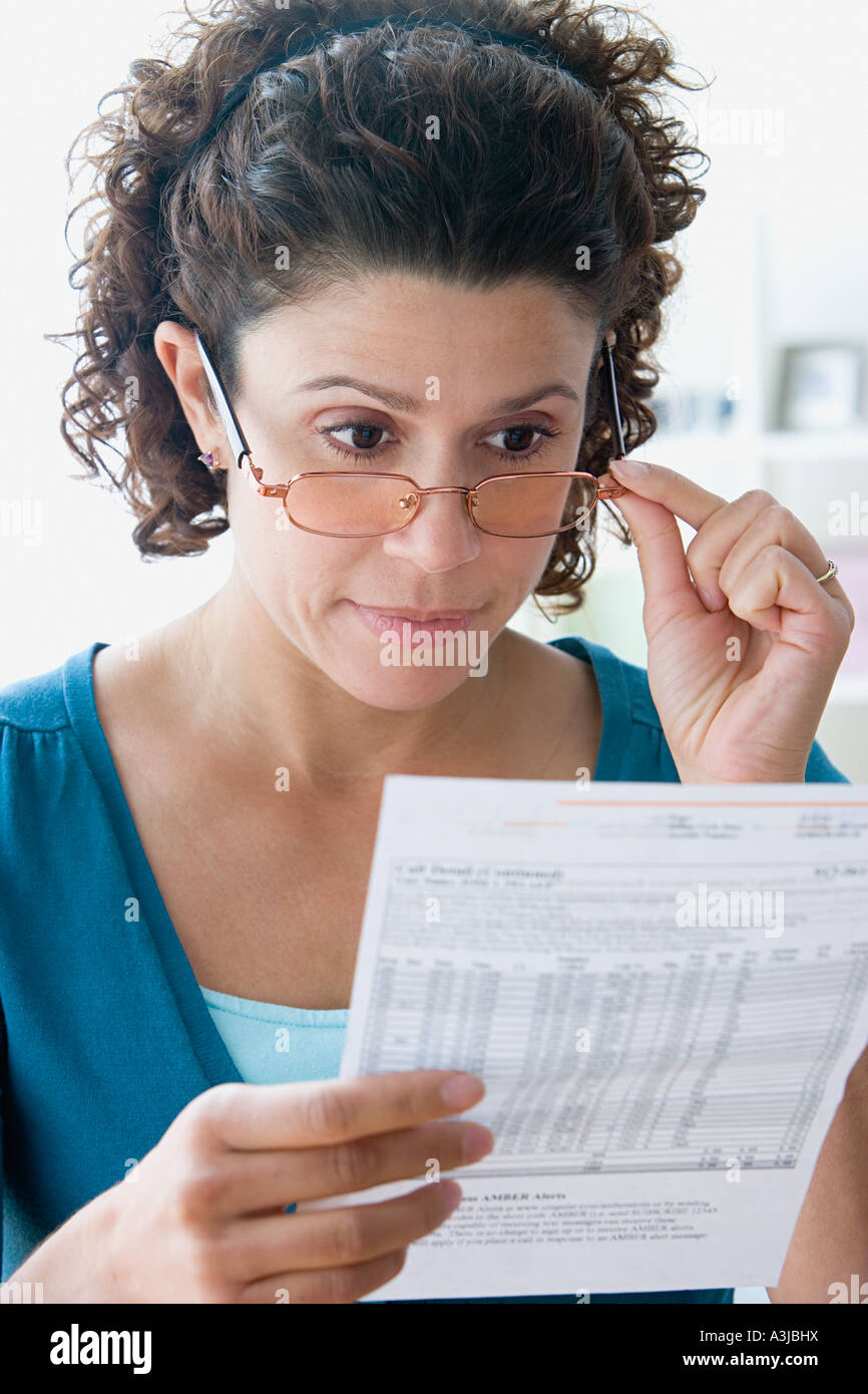 Woman looking at a bank statement Stock Photo - Alamy