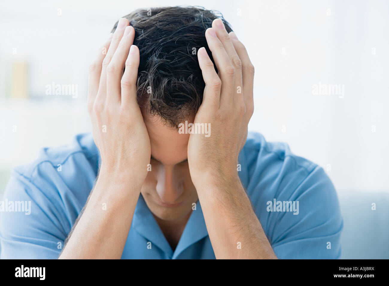 Man with head in hands Stock Photo - Alamy