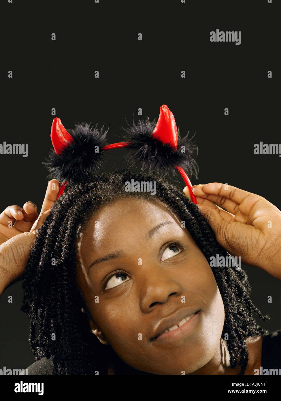 Woman wearing devil horns Stock Photo - Alamy
