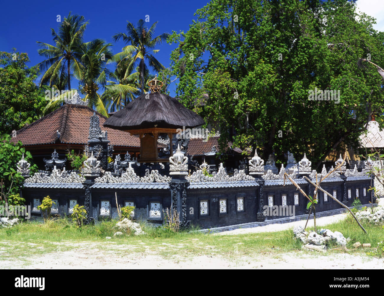 Traditional Balinese temple situated on the beach front under a blue ...