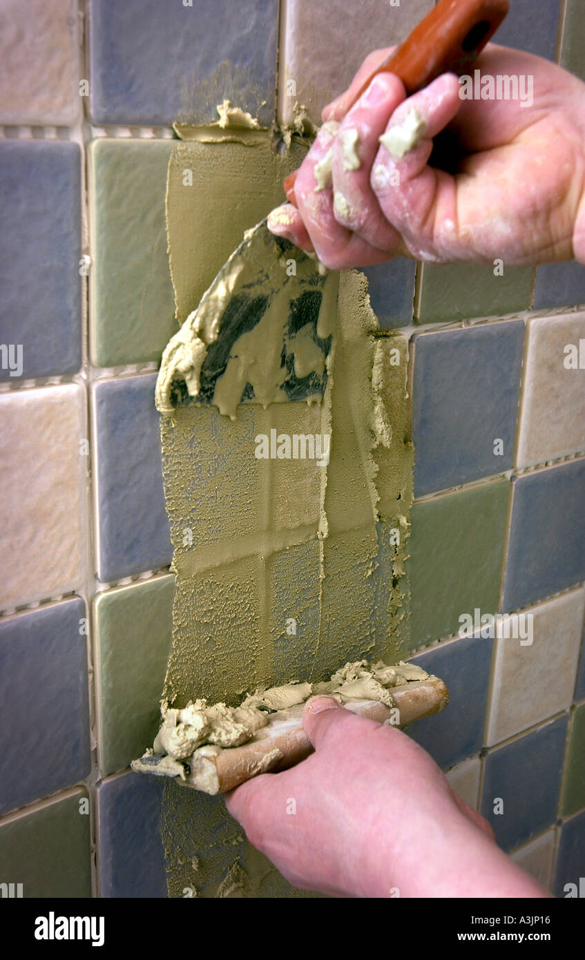 APPLYING GROUT IN A BATHROOM WITH PILKINGTON TILES Stock Photo - Alamy