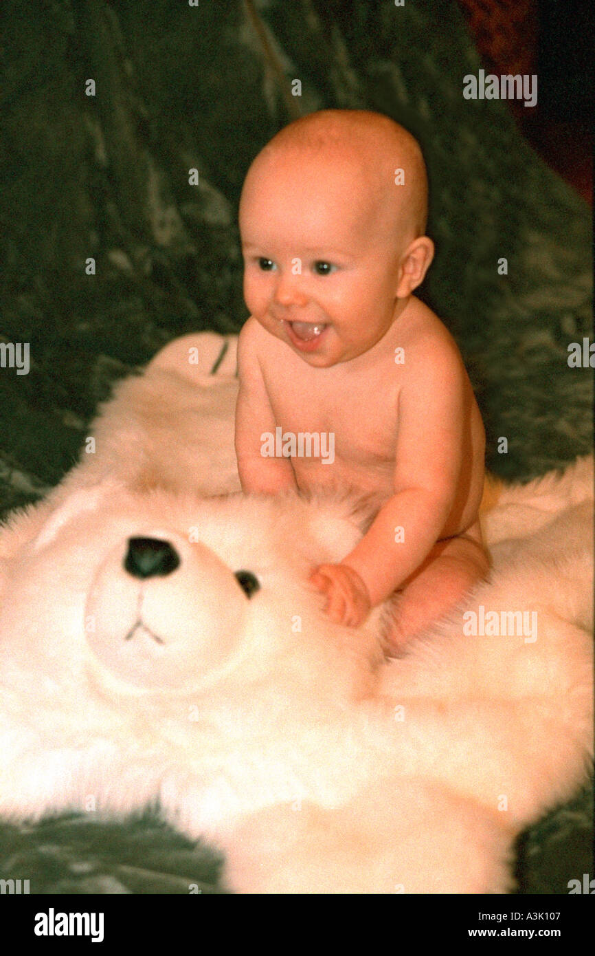 Baby boy smiling happily sitting on stuffed polar bear rug. St Paul ...