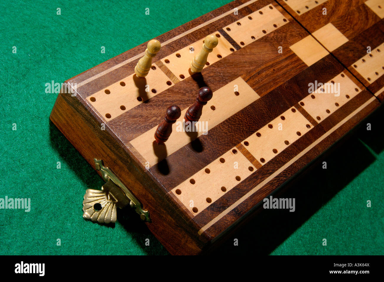 Traditional wooden cribbage board with wooden shaped pegs standing on ...