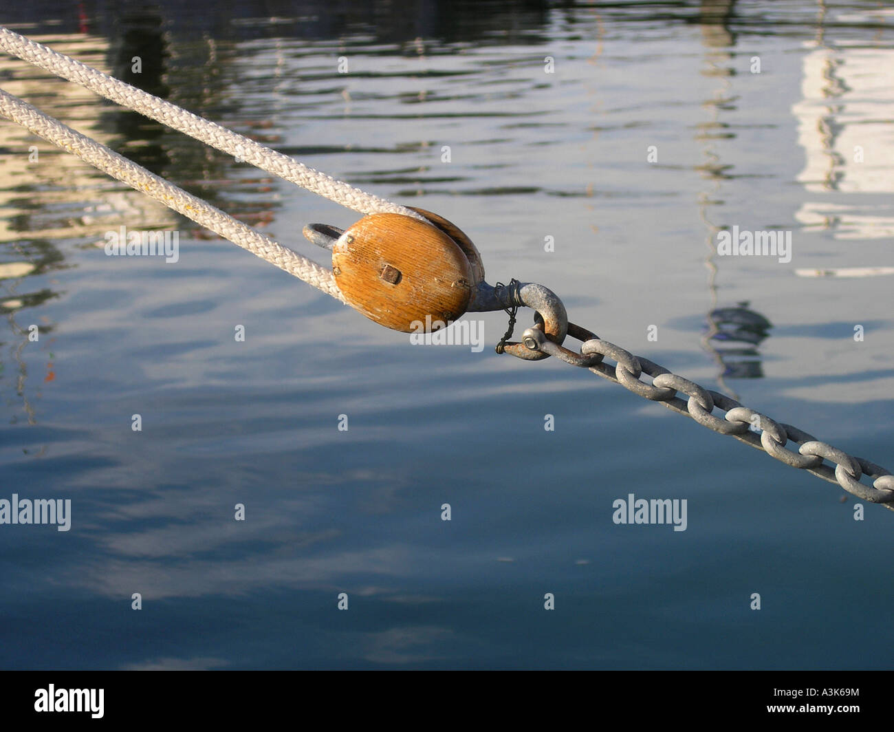 Traditional wooden block and tackle on a sailing boat with water and ...