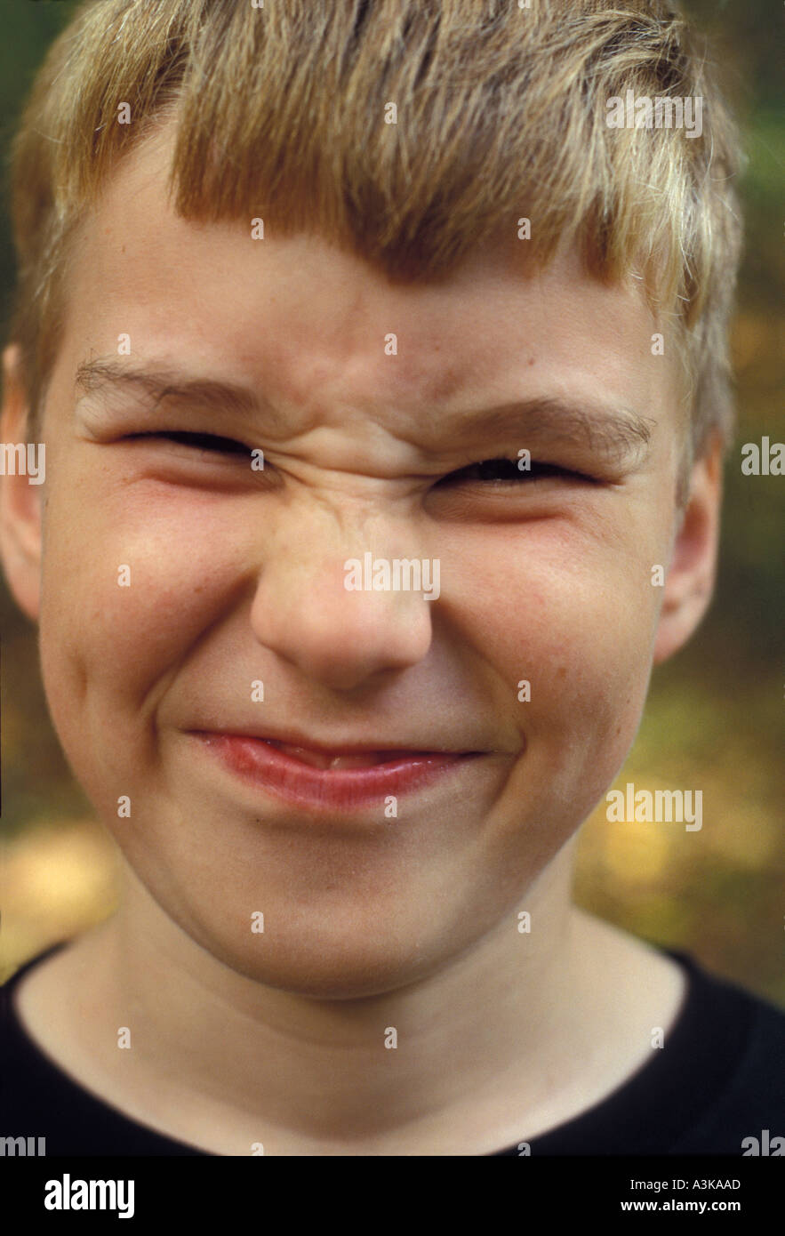 Young boy makes a squinty eyed silly face Stock Photo - Alamy
