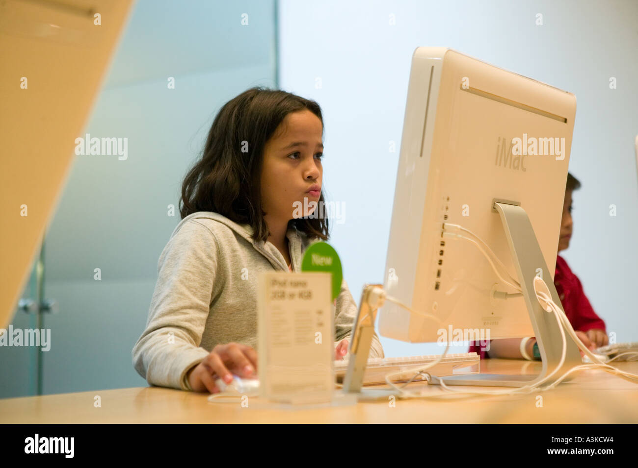 A young girl tries out an iMac desktop computer at the Apple store in ...