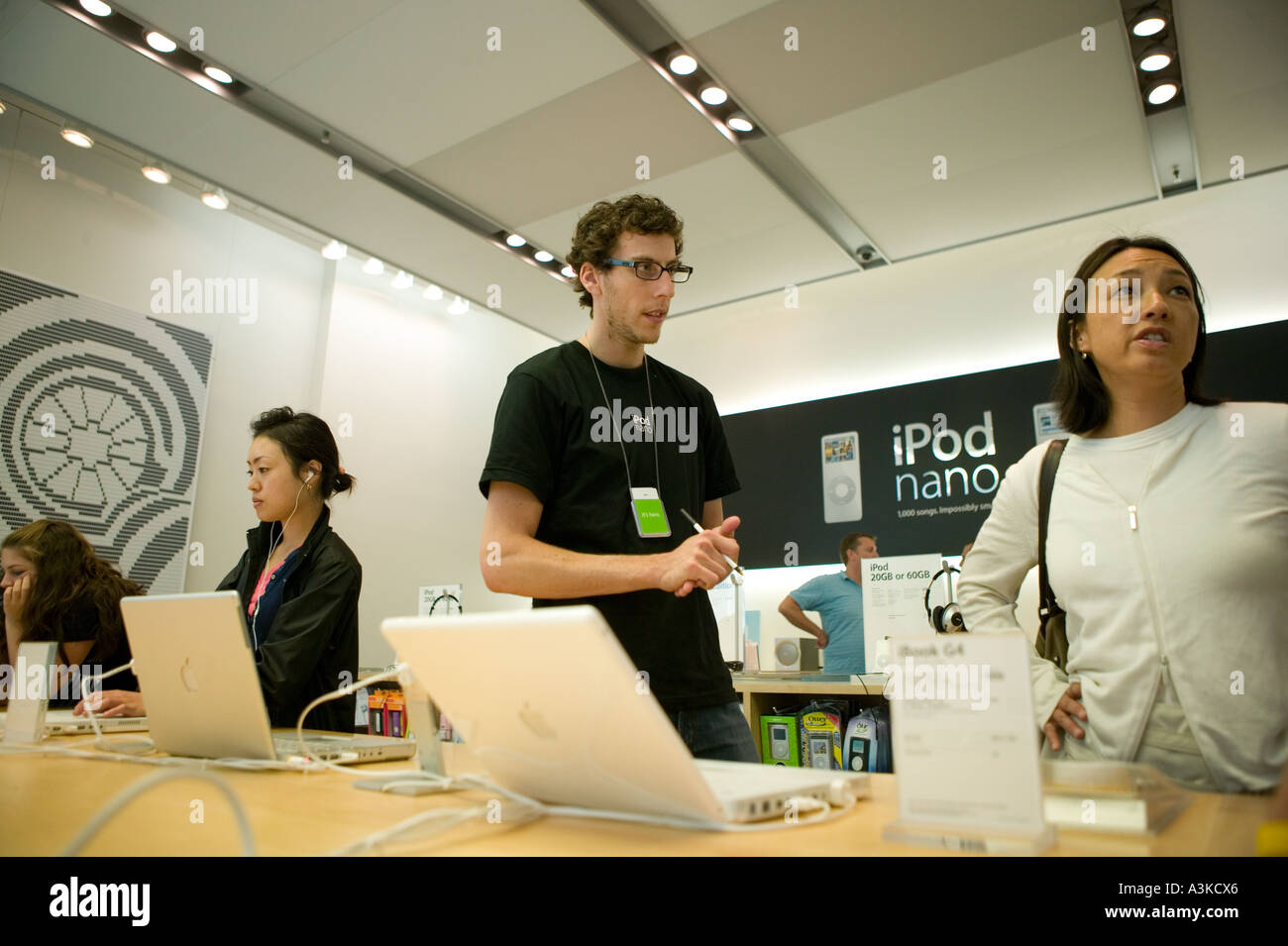 A salesperson advises a woman about products at the Apple store in SoHo ...
