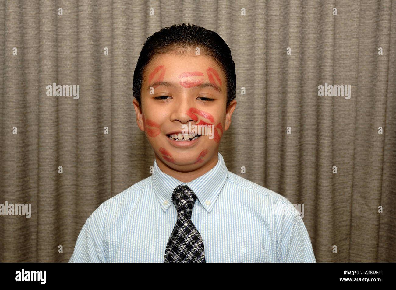 Boy (8-10) smiling, portrait, close-up, wearing shirt and tie with kiss ...