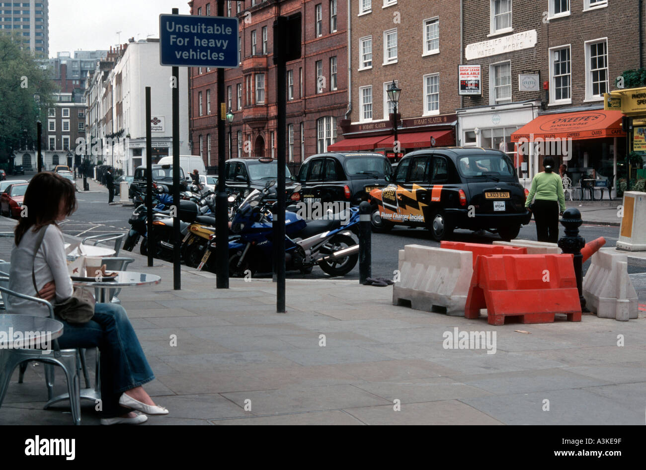 Ordinary street scene in London England with taxis parked motorcycles ...