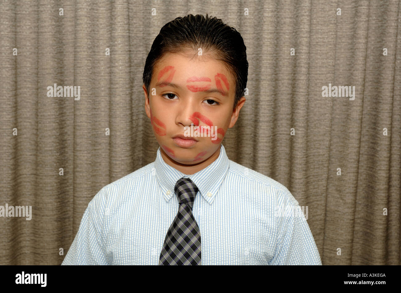 Boy (8-10) portrait, close-up, wearing shirt and tie with kiss marks ...