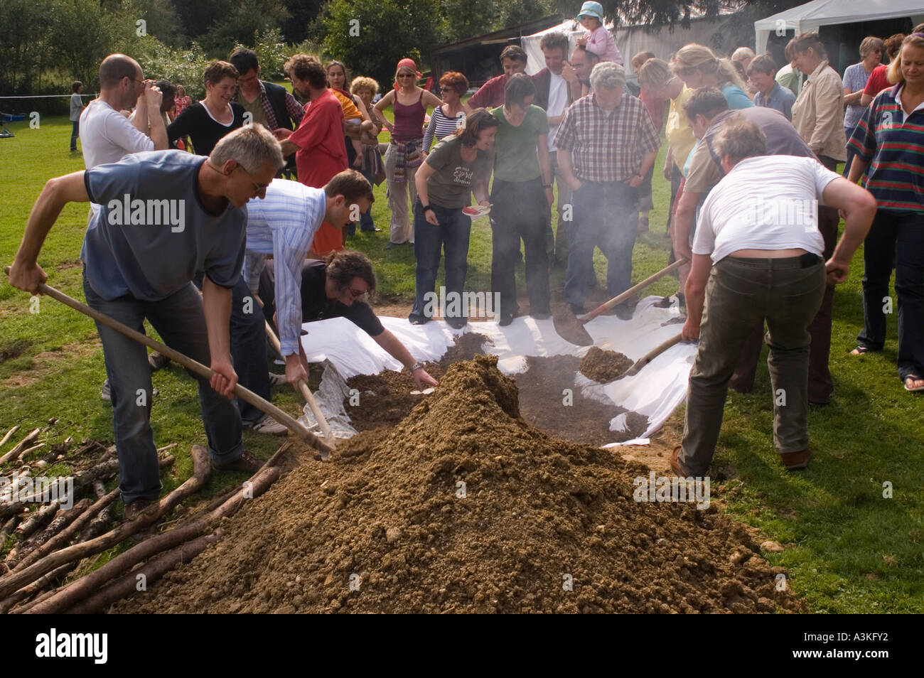 Covering the pit oven at a curanto, cooking in a pit oven, vegetables ...