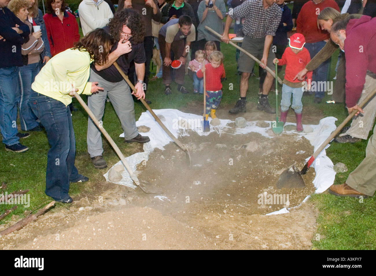 Opening the pit oven at a curanto, cooking in a pit oven, vegetables ...