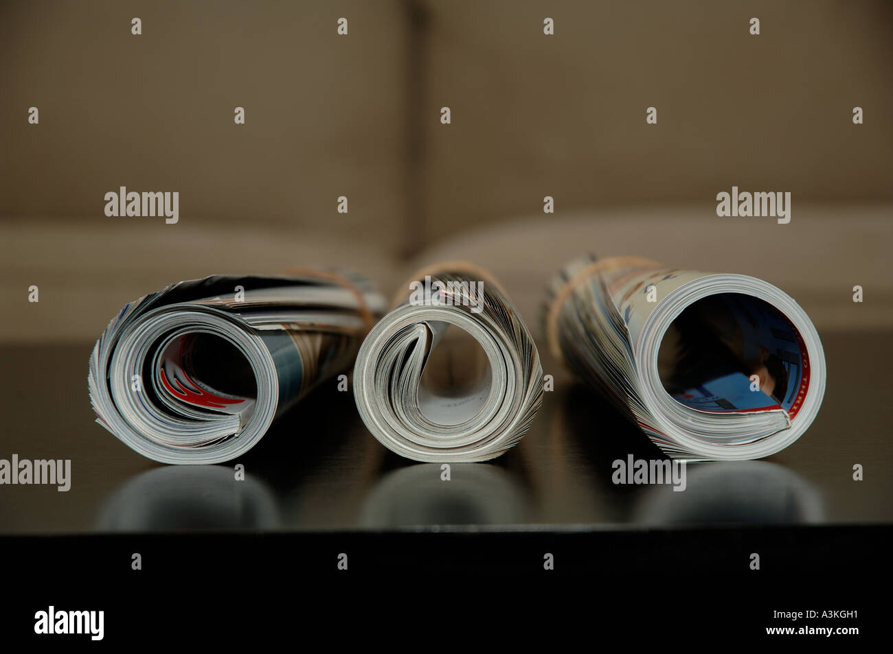 Rolled up magazines over coffee table Stock Photo - Alamy