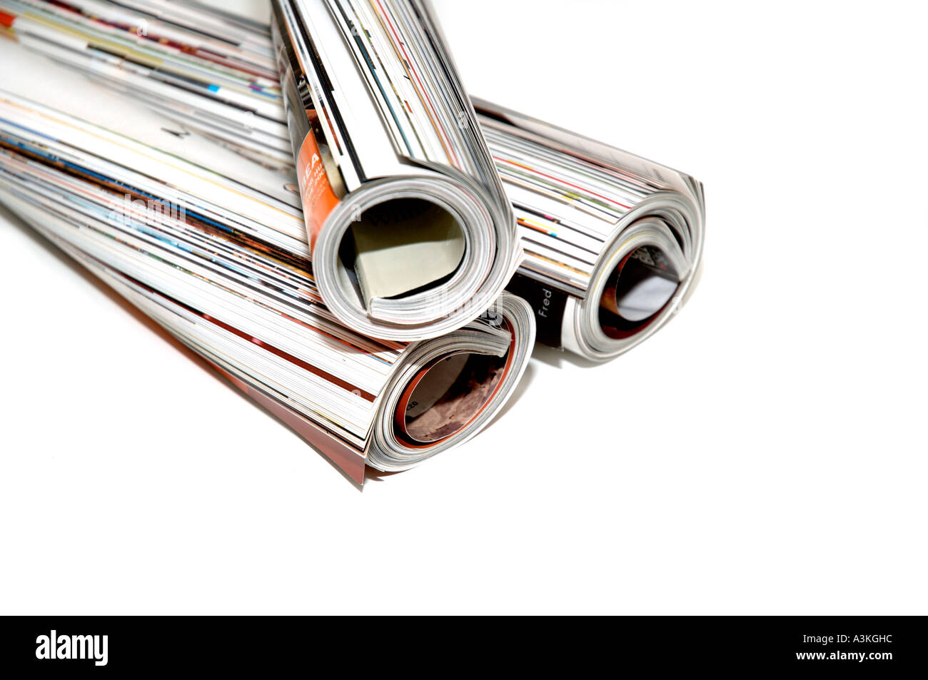 Rolled up magazines over white isolated background Stock Photo - Alamy