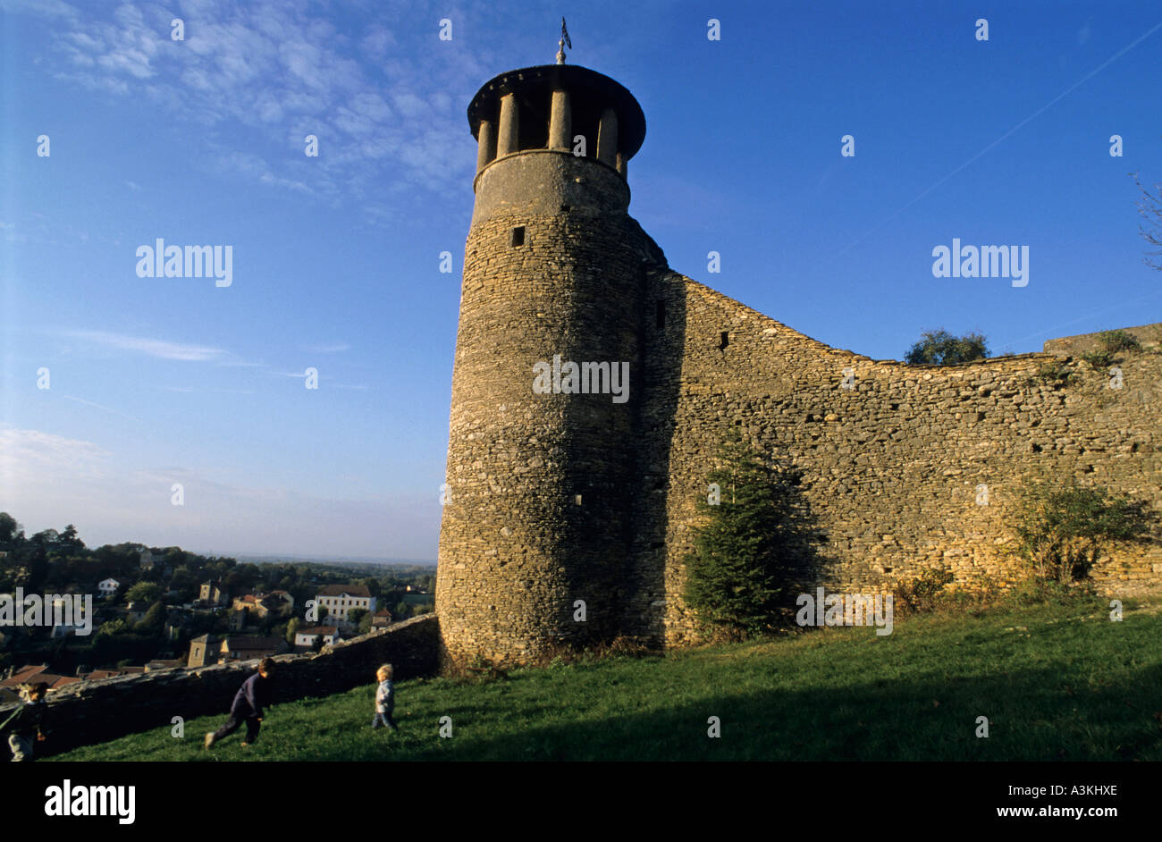 Children playing next to fortress ramparts in the village of Cremieu ...