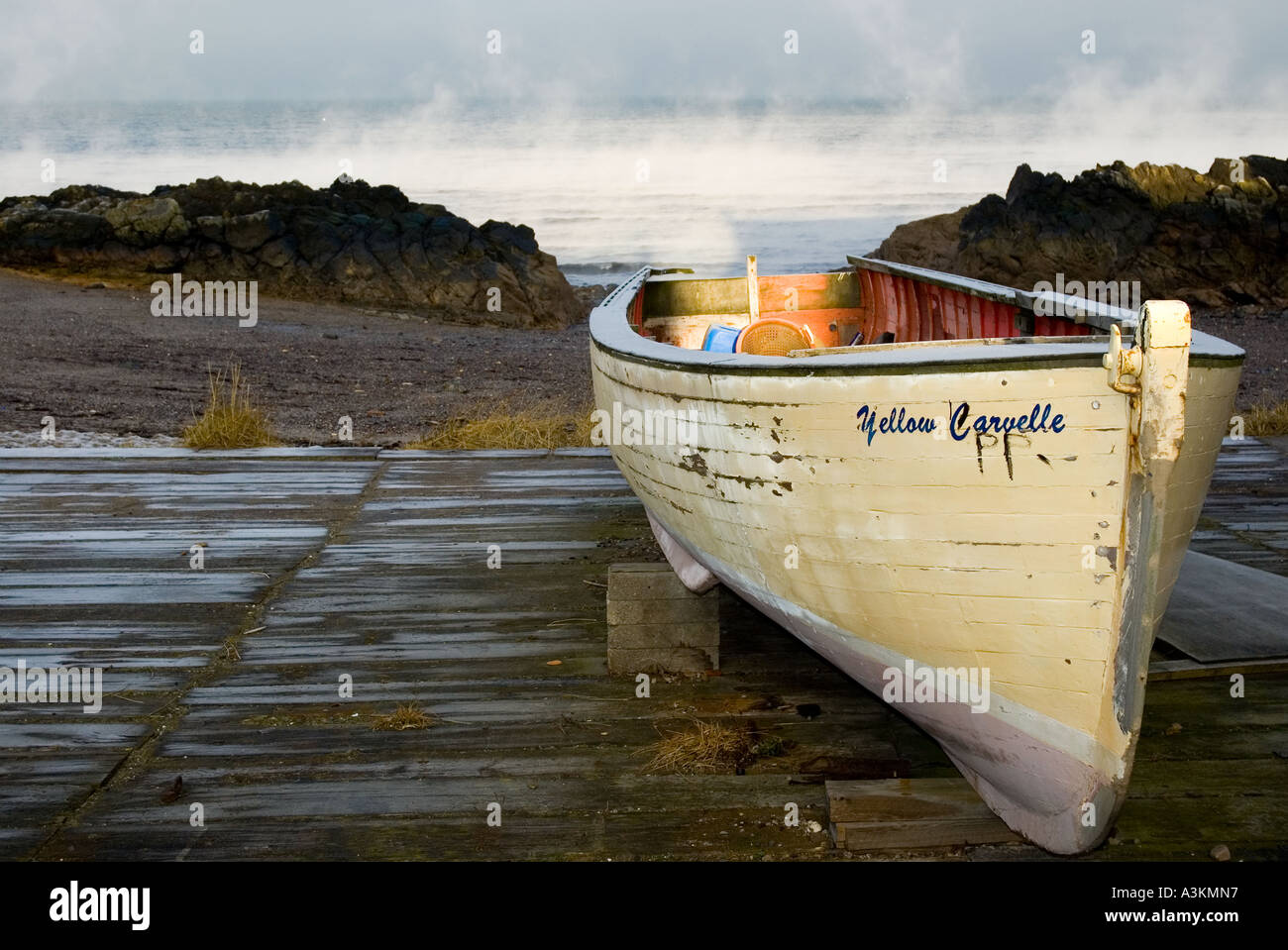 Wooden boat on the shore and steam rising from the water, Cockenzie ...