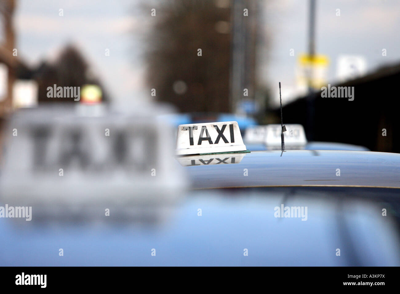 Taxi signs on top of minicabs in taxi rank Stock Photo - Alamy