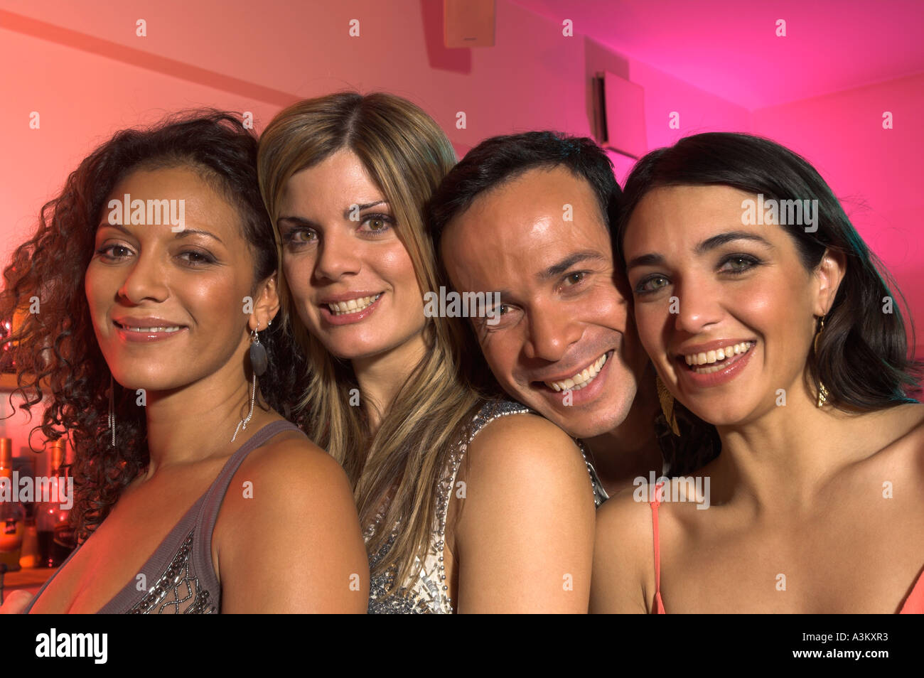 group of four smiling friends posing on a night out Stock Photo - Alamy