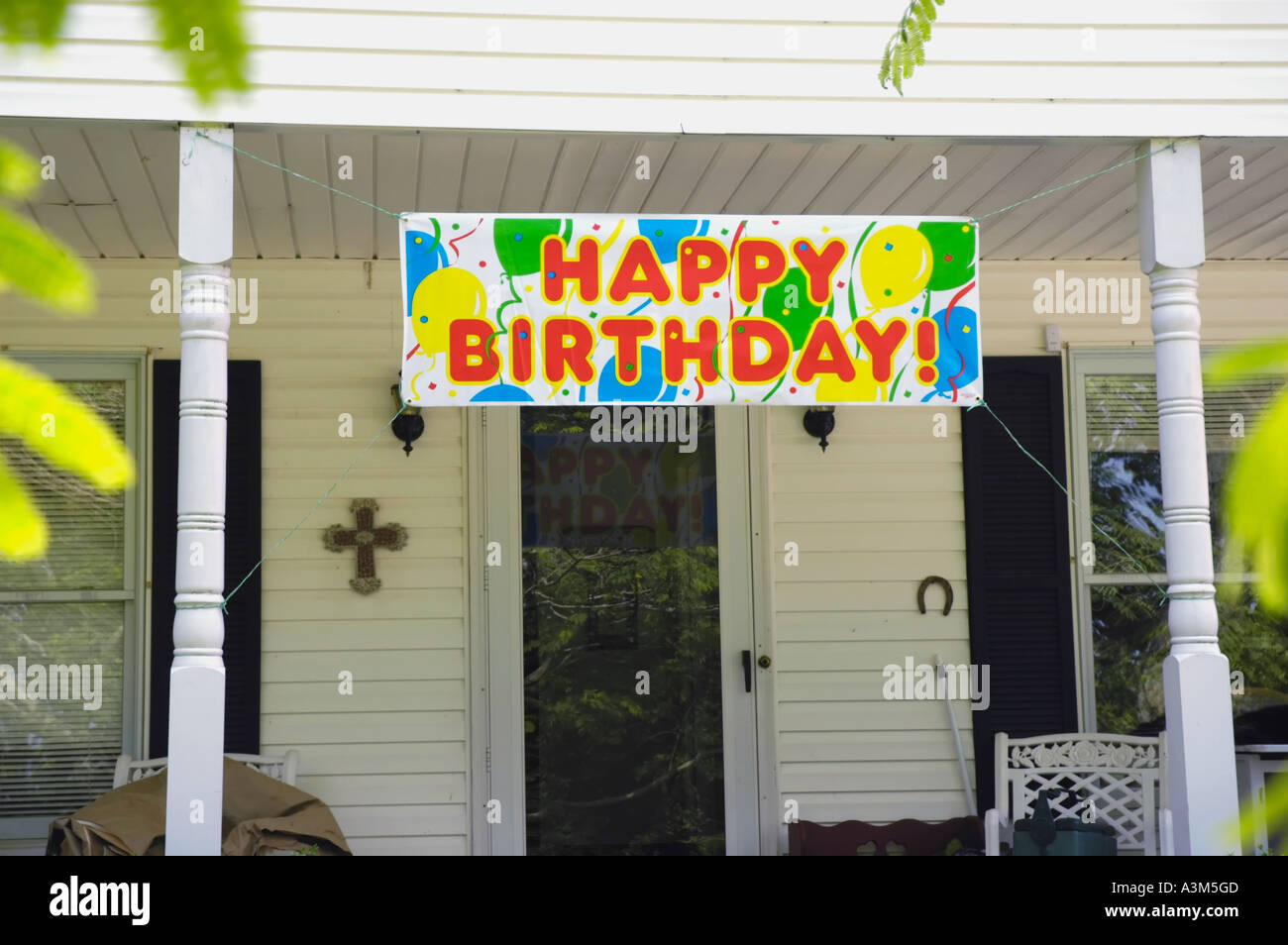 Colorful Happy Birthday banner hanging from the front porch of a home ...