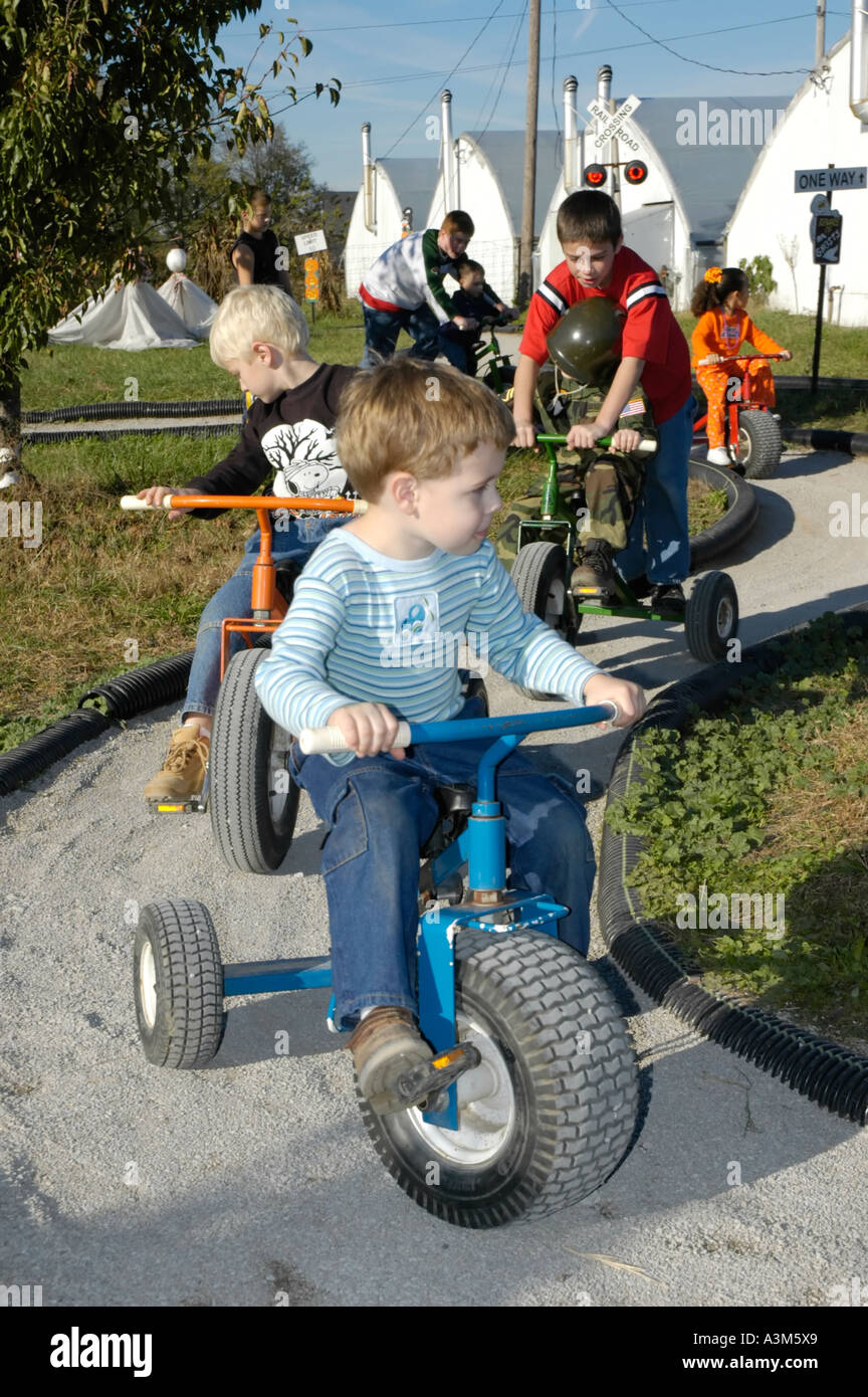 Young children having fun on a tricycle riding track Stock Photo - Alamy