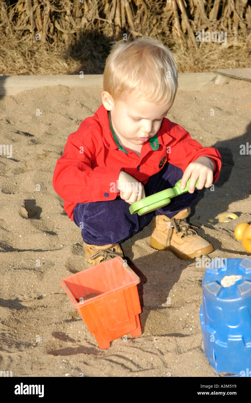 Young boy playing in a sandbox Stock Photo - Alamy