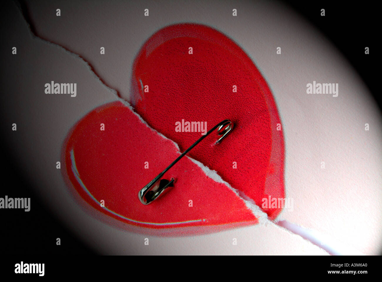 broken red love heart repaired with a safety pin Stock Photo - Alamy