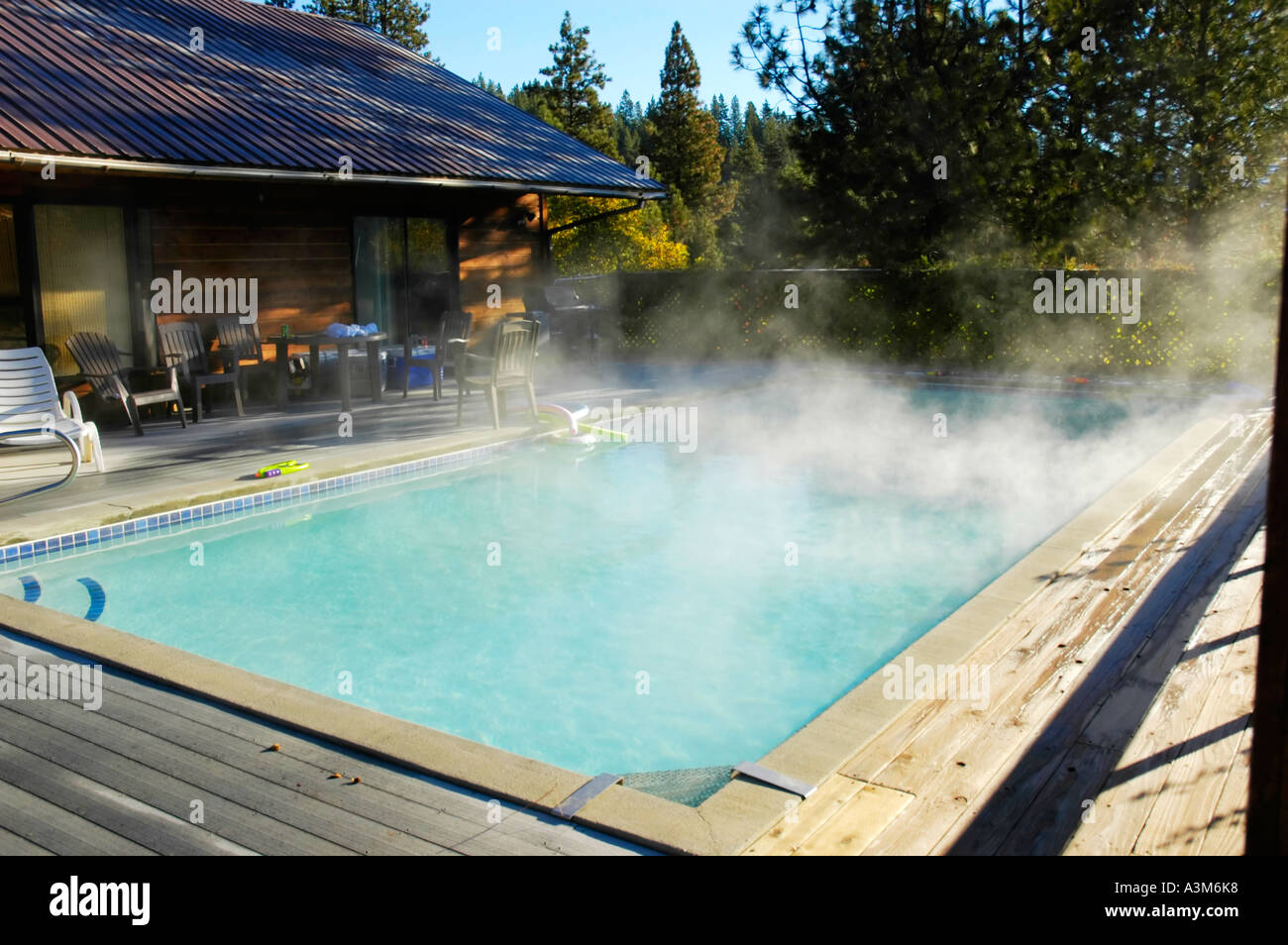 Steam rising from a swimming pool fed by a hot spring in Idaho USA ...