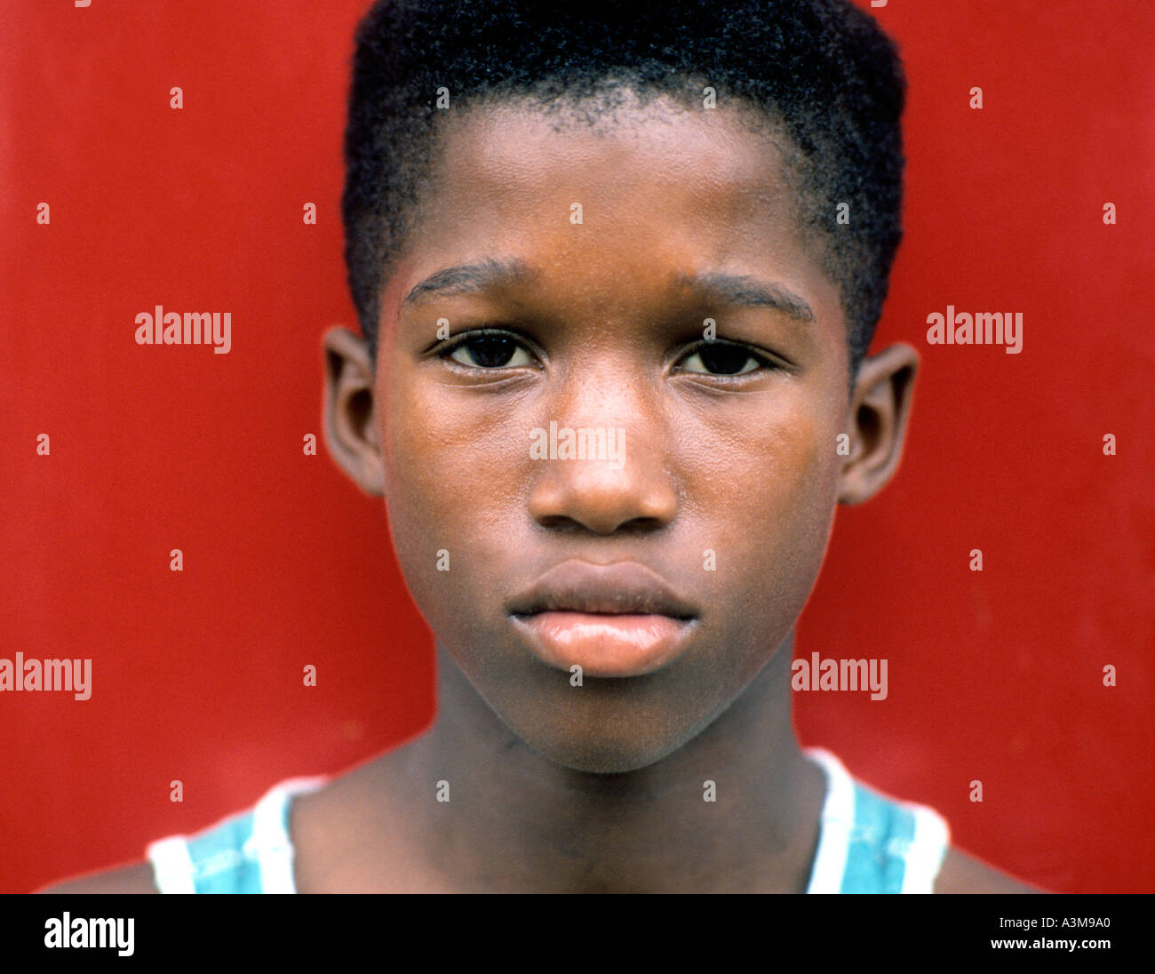 Black Afro boy in front of a red wall Stock Photo - Alamy