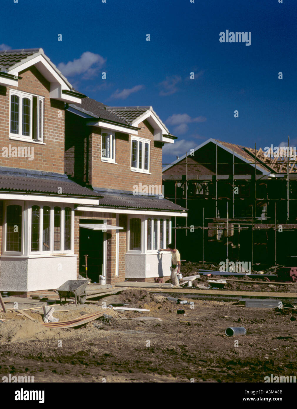 House building; decorator painting a finished house in a new housing ...
