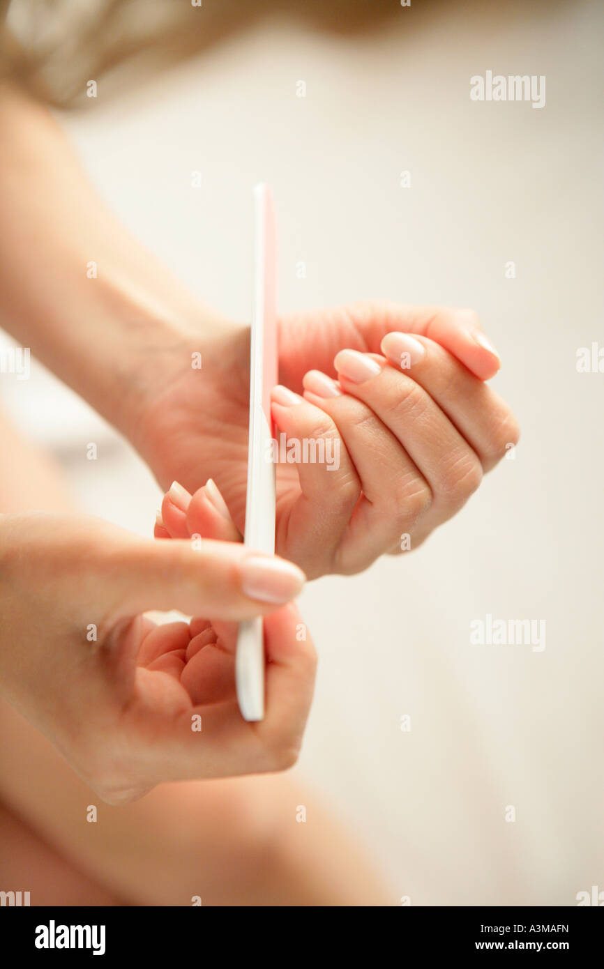 Young woman filing nails Stock Photo - Alamy