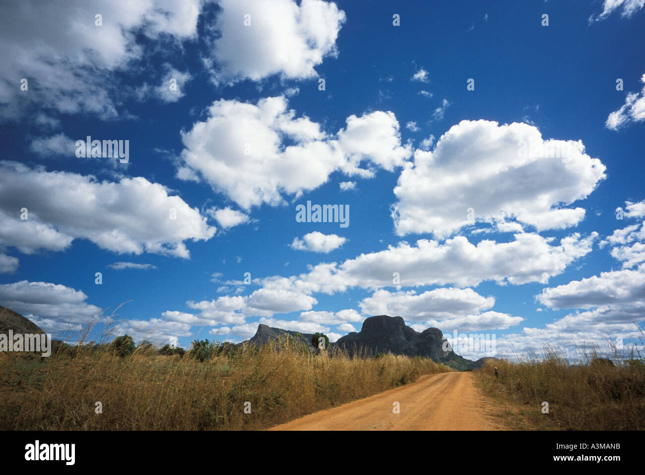 Open dirt road through Northern Mozambique under bright blue sky with ...