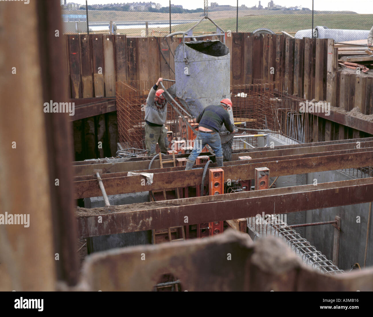 Workmen pouring concrete during the construction of a sewage pumping ...