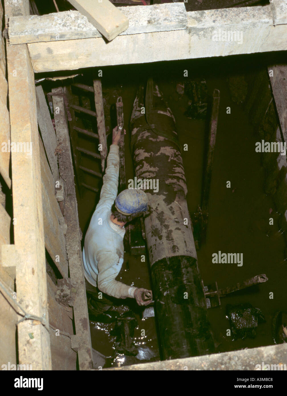 Pipe burster, with UPVC sewer pipe attached, being fed into the ...