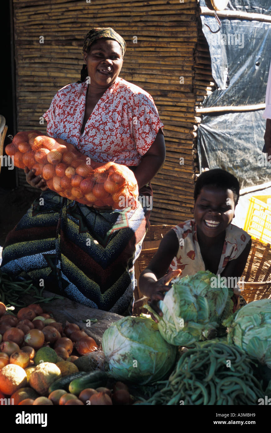 Black african mother and her happy daughter selling produce in a ...