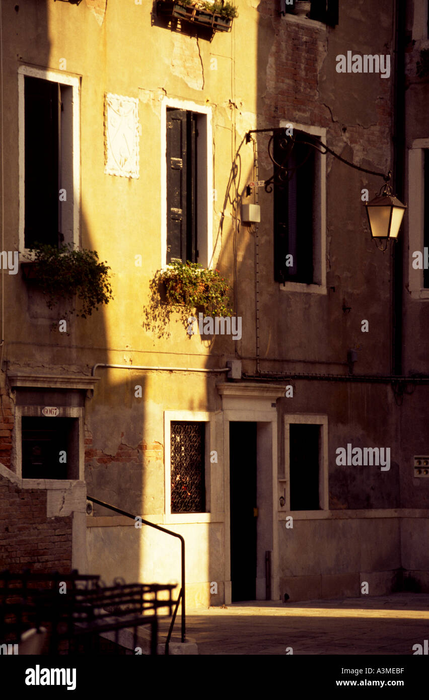 Afternoon sunlight in to an alleyway entrance to yellow building with ...