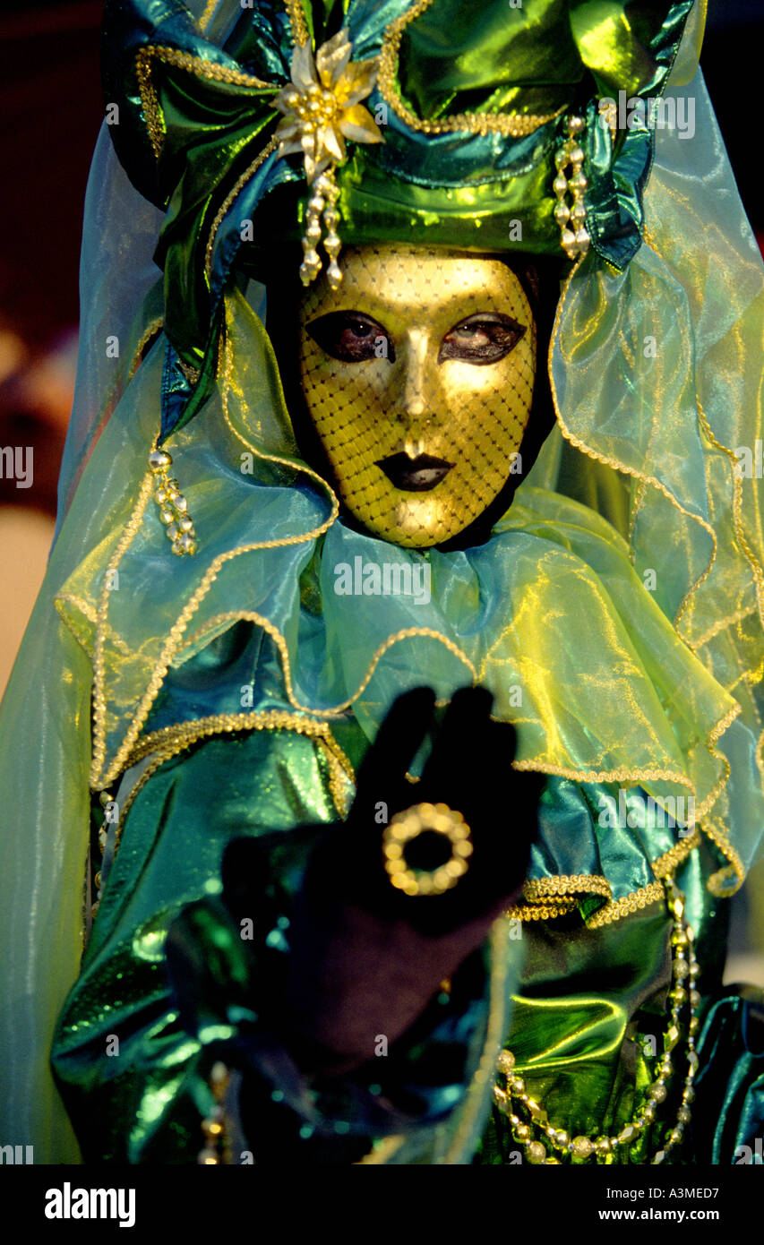 Portrait person in a gold mask dressed in a rich green oriental themed ...