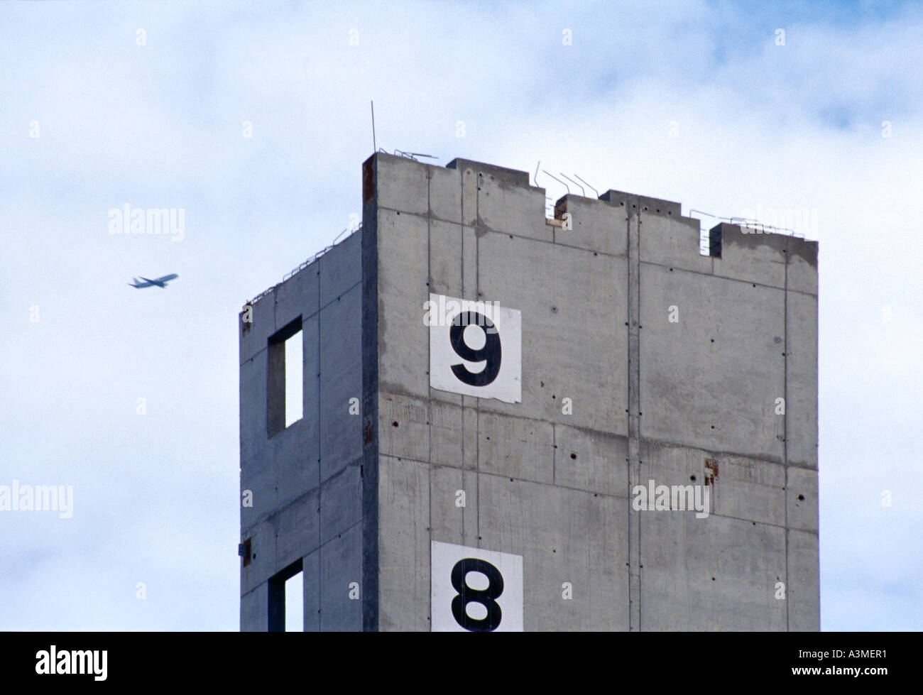 Concrete building under construction, plane flying in the background ...