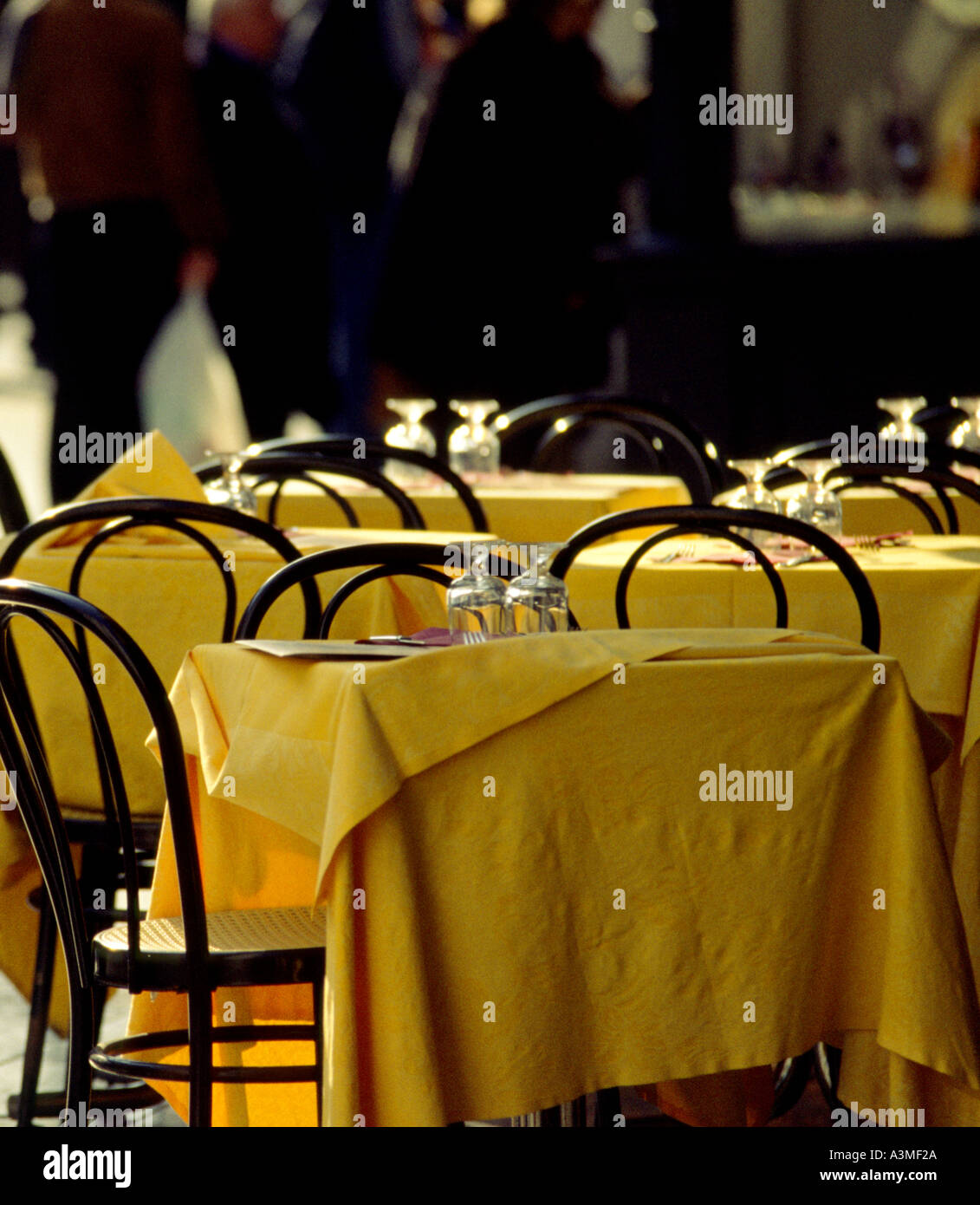 Outdoor coffee restaurant tables still empty with bright yellow linen ...