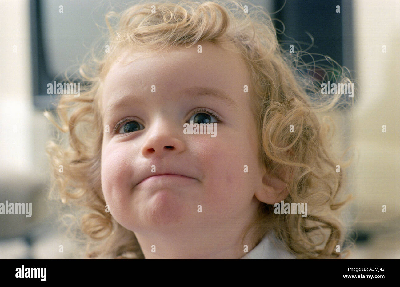 Fair haired young girl with curly hair and cheeky expression Stock ...