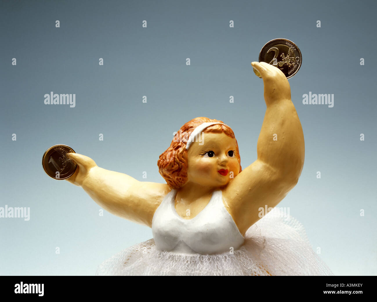 DOLL FIGURINE HOLDING 1 AND 2 EURO COINS Stock Photo - Alamy