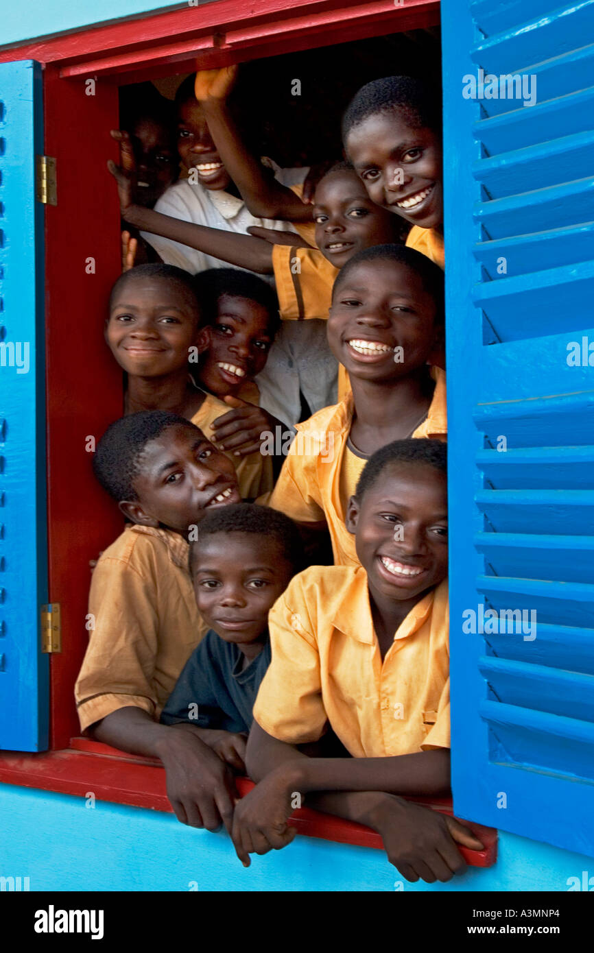 Happy smiling school children from Ghana at window of their classroom ...